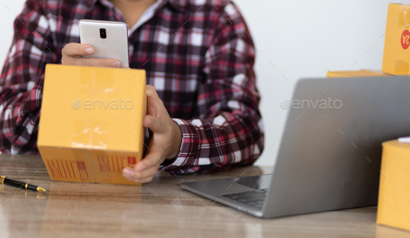 Small business owner using mobile app on smartphone scanning barcode ...