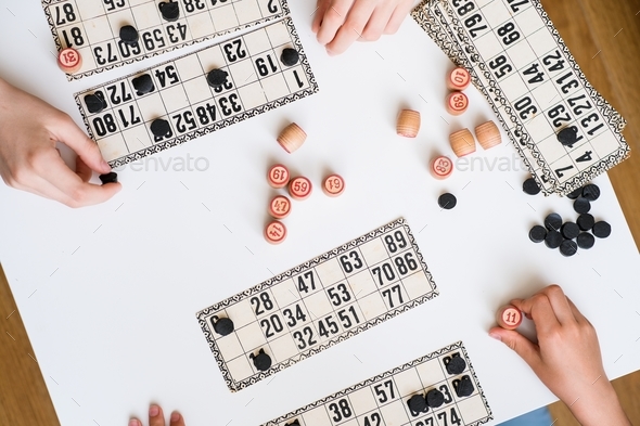 Two children are playing board games. Lotto Bingo Game set. Cozy home ...