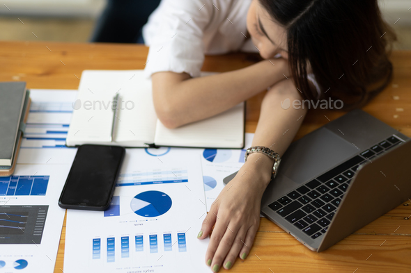 Business woman at a desk in the office who is tired from overwork ...