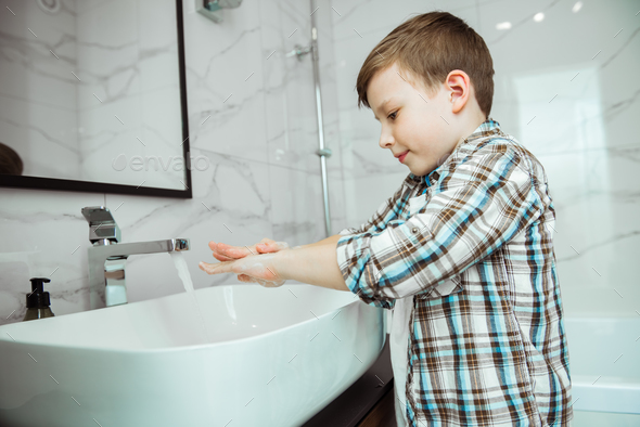 Cute kid boy washing hand under tap water in bathroom Stock Photo by irinapavlova1