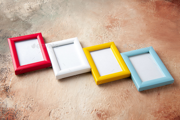 Front view of four photo frames hung on side by side on mix color wall ...