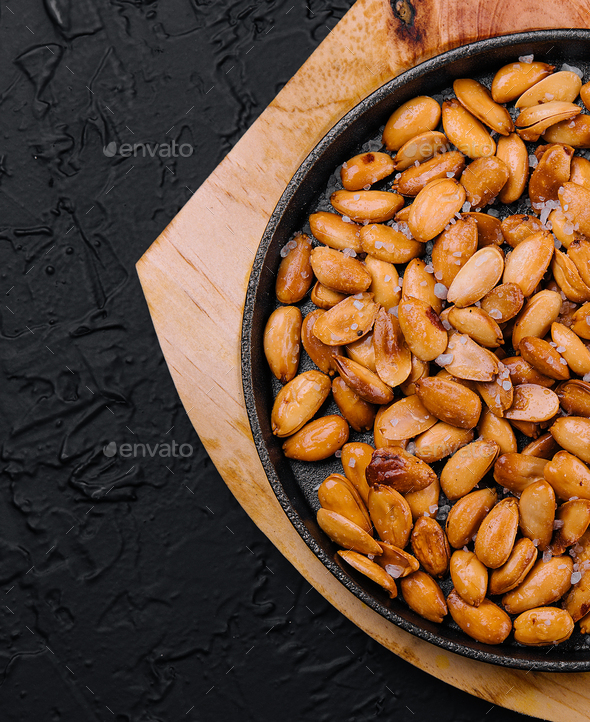 Organic roasted salty peanuts in a pan Stock Photo by AntAlexStudio