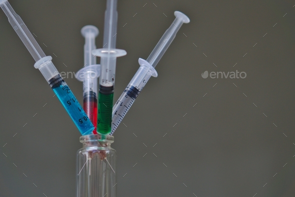 Syringes with colorful liquids in the transparent container Stock Photo ...