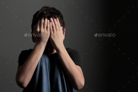 Boy covering his face to hide his tears, the concept of childhood ...