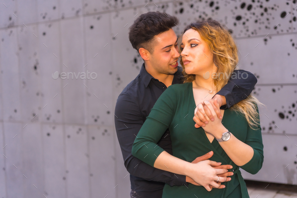 Couple in love hugging and posing outdoors Stock Photo by wirestock