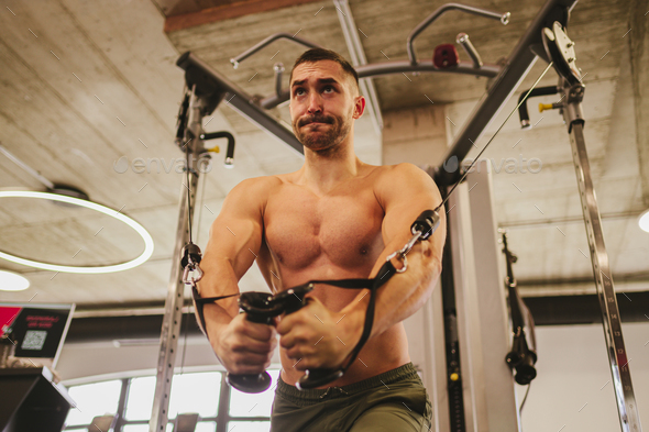 Low angle view of an attractive shirtless bodybuilder pulling heavy ...