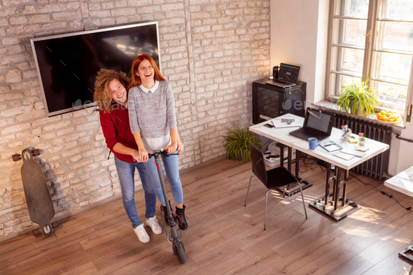 Business people having fun with electric scooter at the office Stock ...