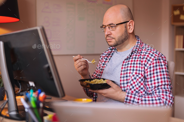 Man taking lunch break while working in home office Stock Photo by ...