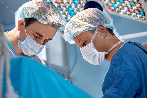 Faces of surgeons close-up during a complex and intense operation ...