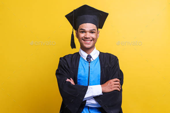 Young man wearing graduation cap and ceremony robe happy face smiling ...
