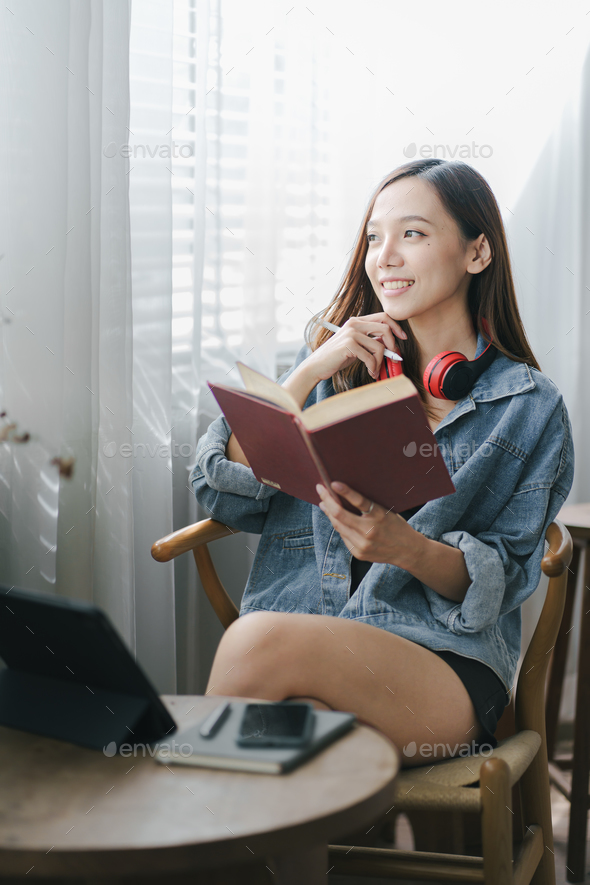 Asian female college student reading a book in a cafe girl working in a ...