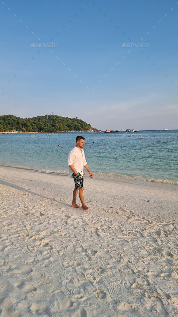 men walking on a sandbar in the ocean of Koh lipe Southern Thailand ...
