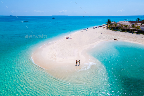 men and women walking on a sandbar in the ocean of Koh lipe Southern ...