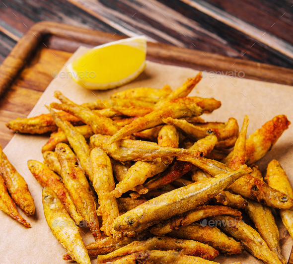 Dried small salted fish heap on crumpled paper Stock Photo by AntAlexStudio