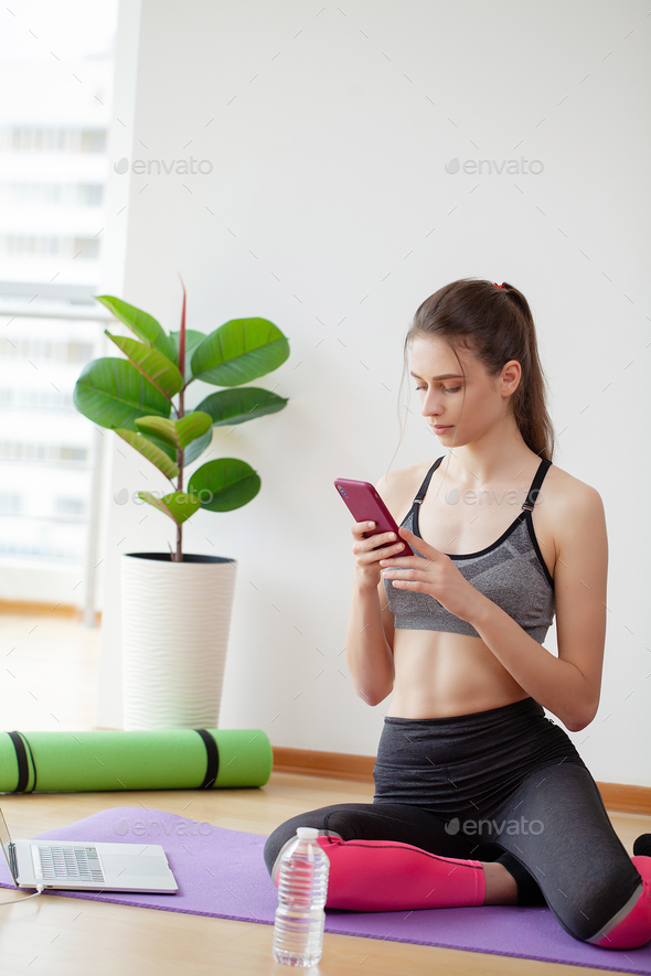Beautiful young woman repeating exercises while watching online ...