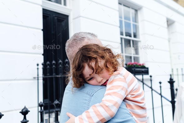 Father back view Carrying his Sleepy Child. Stock Photo by angelsantana