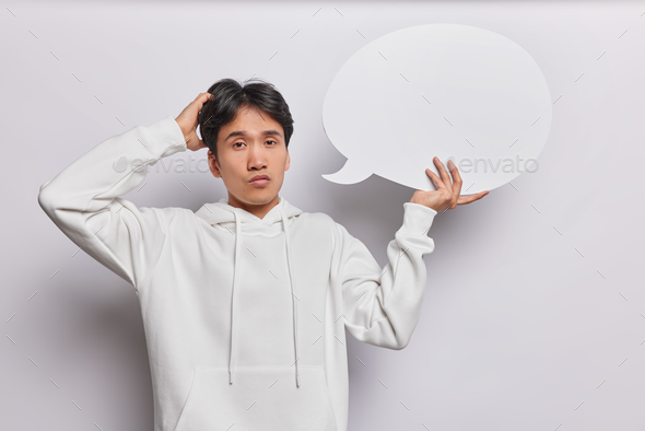 Hesitant young Chinese man scratches head thinks of advertisement to ...