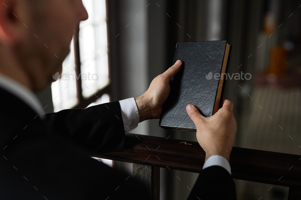 Priest reading Bible during praying Stock Photo by seventyfourimages