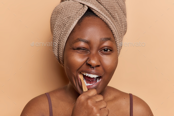Close up shot of black Afro woman with dark skin brushes teeth with ...
