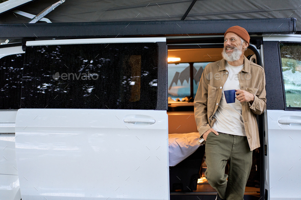 Older man traveler standing near rv camper van drinking coffee enjoying ...