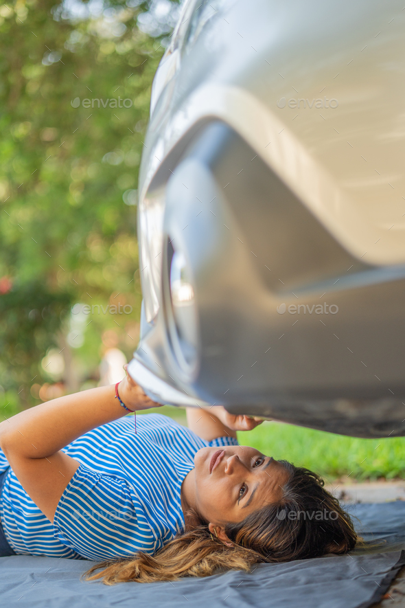 Woman looking under her vehicle Stock Photo by GSR-PhotoStudio | PhotoDune