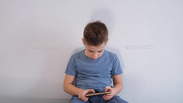 little boy using smartphone over grey background. technology, childhood ...