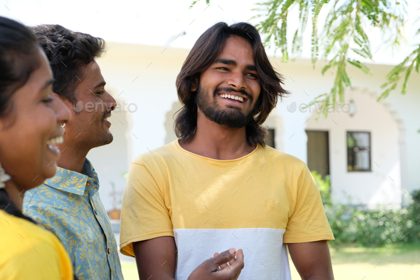 Group of young Indian people happily laughing while standing outdoors ...