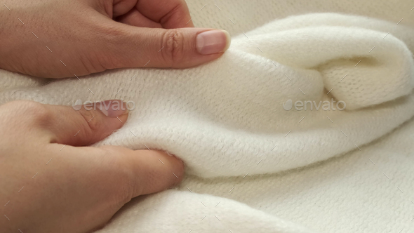 female's hand on the fabric of white plush cloth with soft nap ...