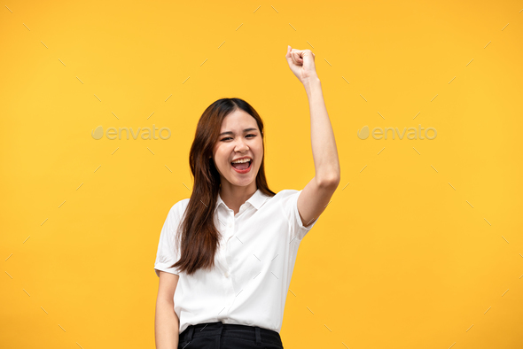 Asian woman wearing white short sleeve shirt and raising one arm while ...