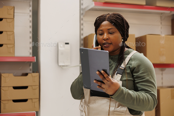 Storehouse employee talking at landline phone Stock Photo by DC_Studio