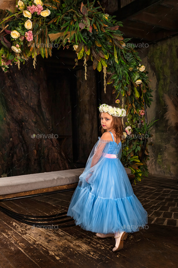Rear view little girl princess wearing art light blue dress with wreath ...