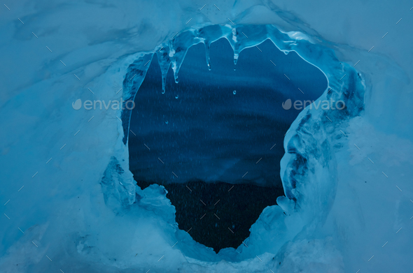 an ice floe with the purest blue ice in the center with dripping water ...