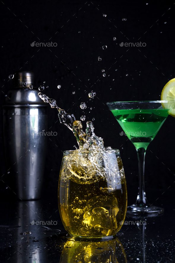 Vertical shot of alcoholic beverages on a black background with ...