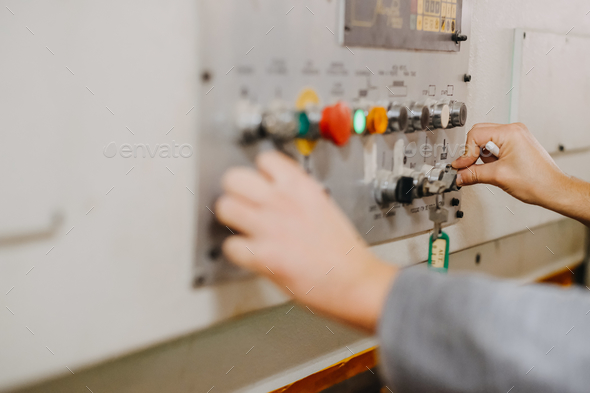Closeup shot of hands operating colorful knobs and buttons on an ...