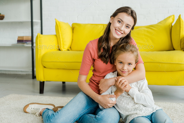 attractive babysitter hugging happy kid in living room Stock Photo by ...