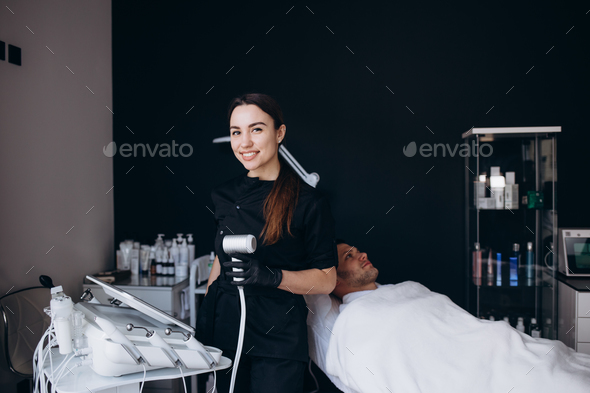 The doctor-cosmetologist makes the procedure Cryotherapy of the facial ...