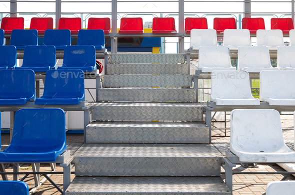 Front view of blue and red plactic seats on sport stadium's grandstand ...