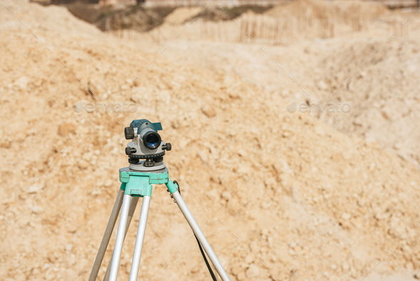 Digital level on tripod with sand mounds on background Stock Photo by ...