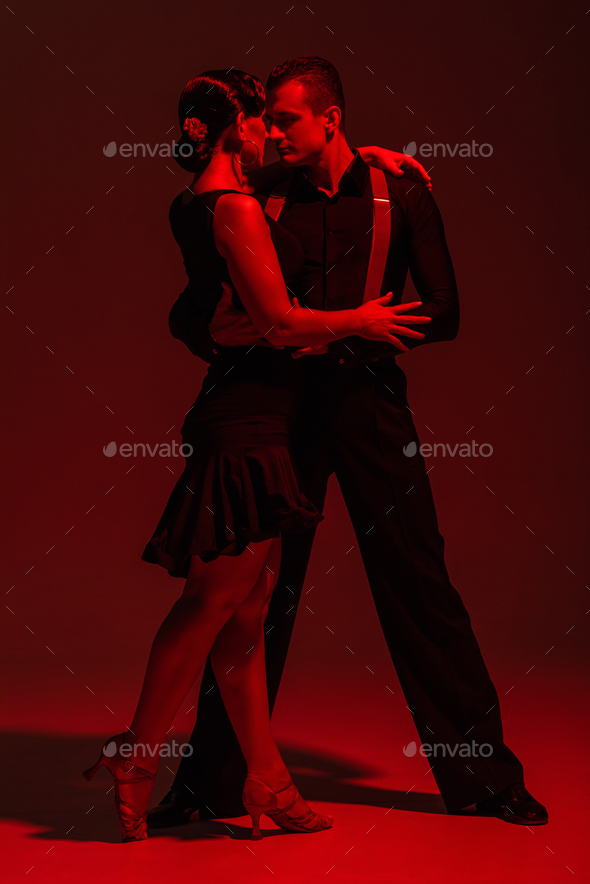 Sensual Couple Of Dancers Performing Tango On Dark Background With Red