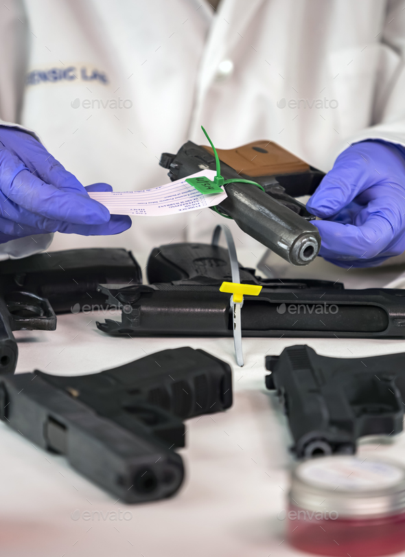 Police scientist notes serial number on sealed firearm in crime lab ...