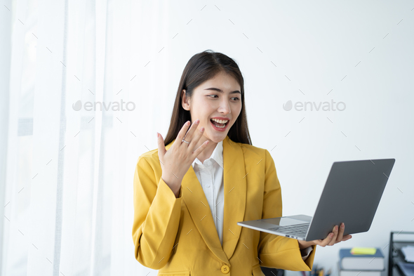 Young female businesswoman working with laptop computer while standing ...