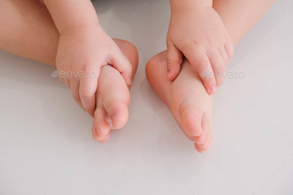 Newborn baby feet in mother's hands. Masseur massaging little baby's ...