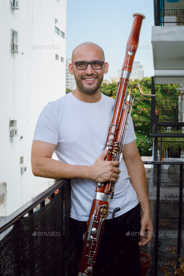 vertical portrait of man smiling at home holding his bassoon Stock ...