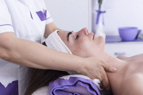 Esthetician performing professional facial massage on woman's face in ...