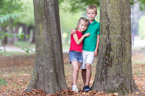 Portrait of two pretty cute children boy and girl standing near big ...