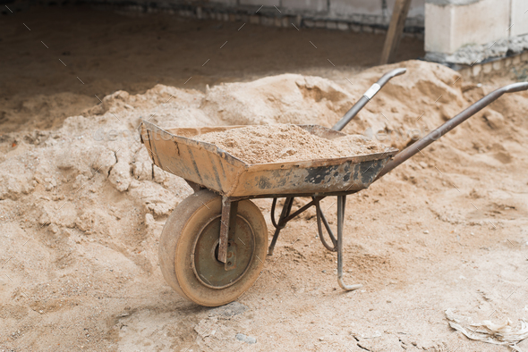 Construction cart with sand outdoors. Wheelbarrow for transportation of ...