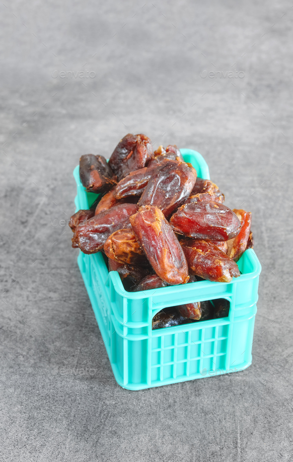 Close up picture of dried organic seedless dates in miniature container ...