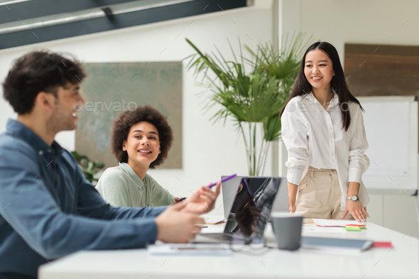 Three Multicultural Young Colleagues Talking During Meeting In Modern ...