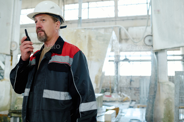 Engineer talking in transmitter with workers Stock Photo by AnnaStills