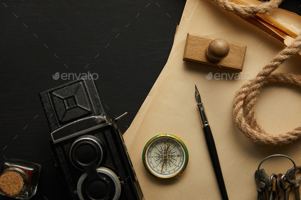top view of vintage camera, paper, fountain pen, compass, stamp and ...